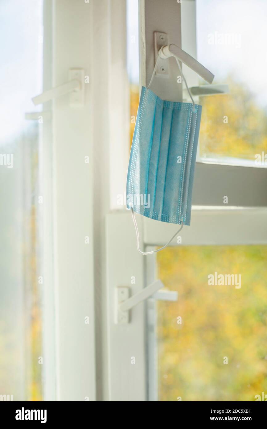 Face mask hanging from window latch Stock Photo - Alamy
