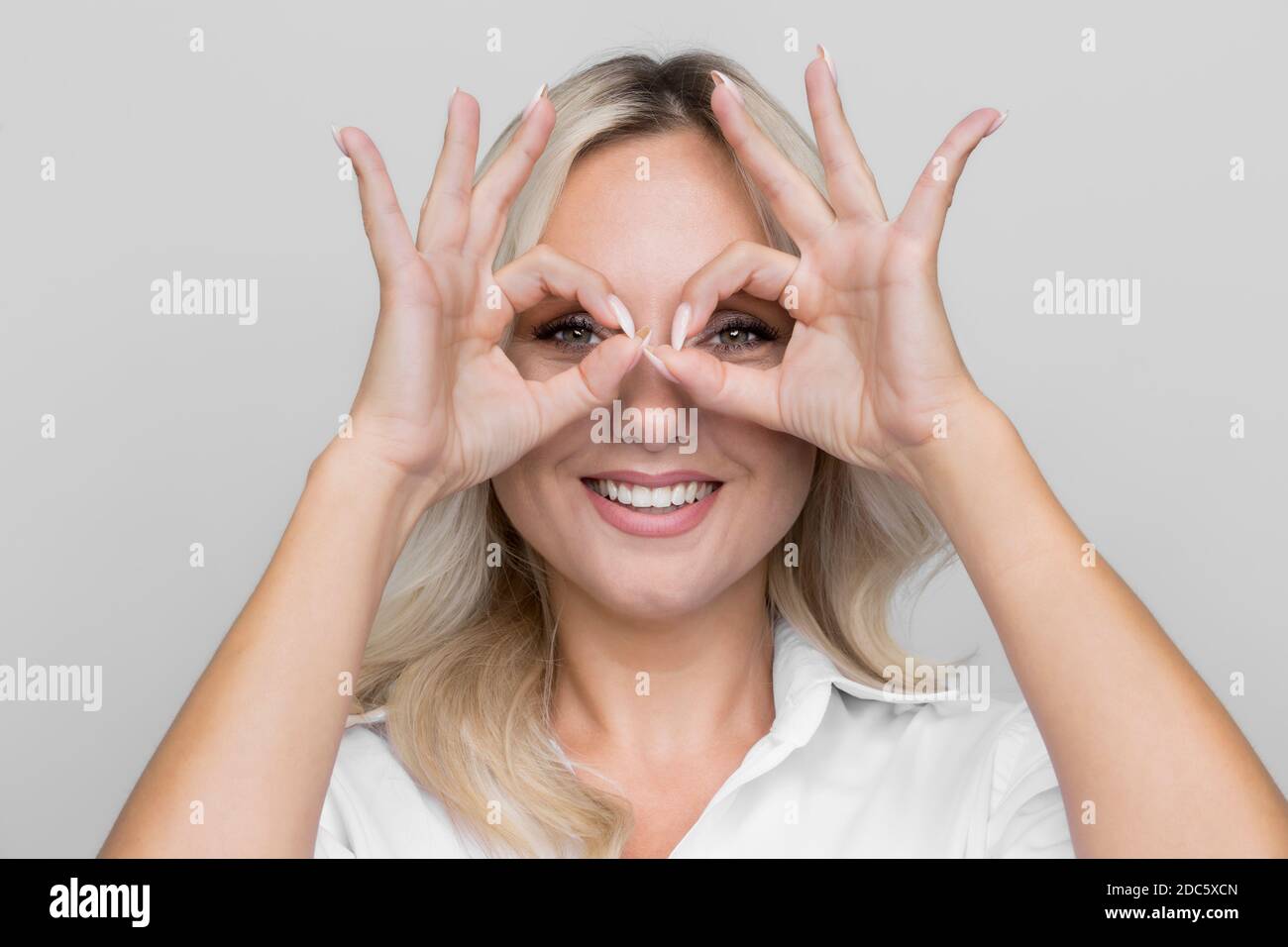 Portrait playful woman gesturing finger goggles Stock Photo - Alamy