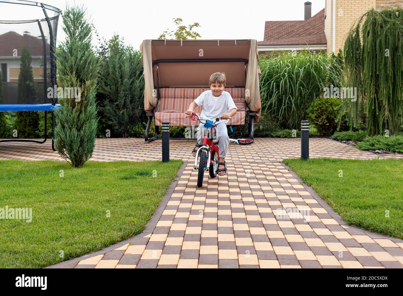 Portrait happy boy riding bicycle in backyard Stock Photo - Alamy