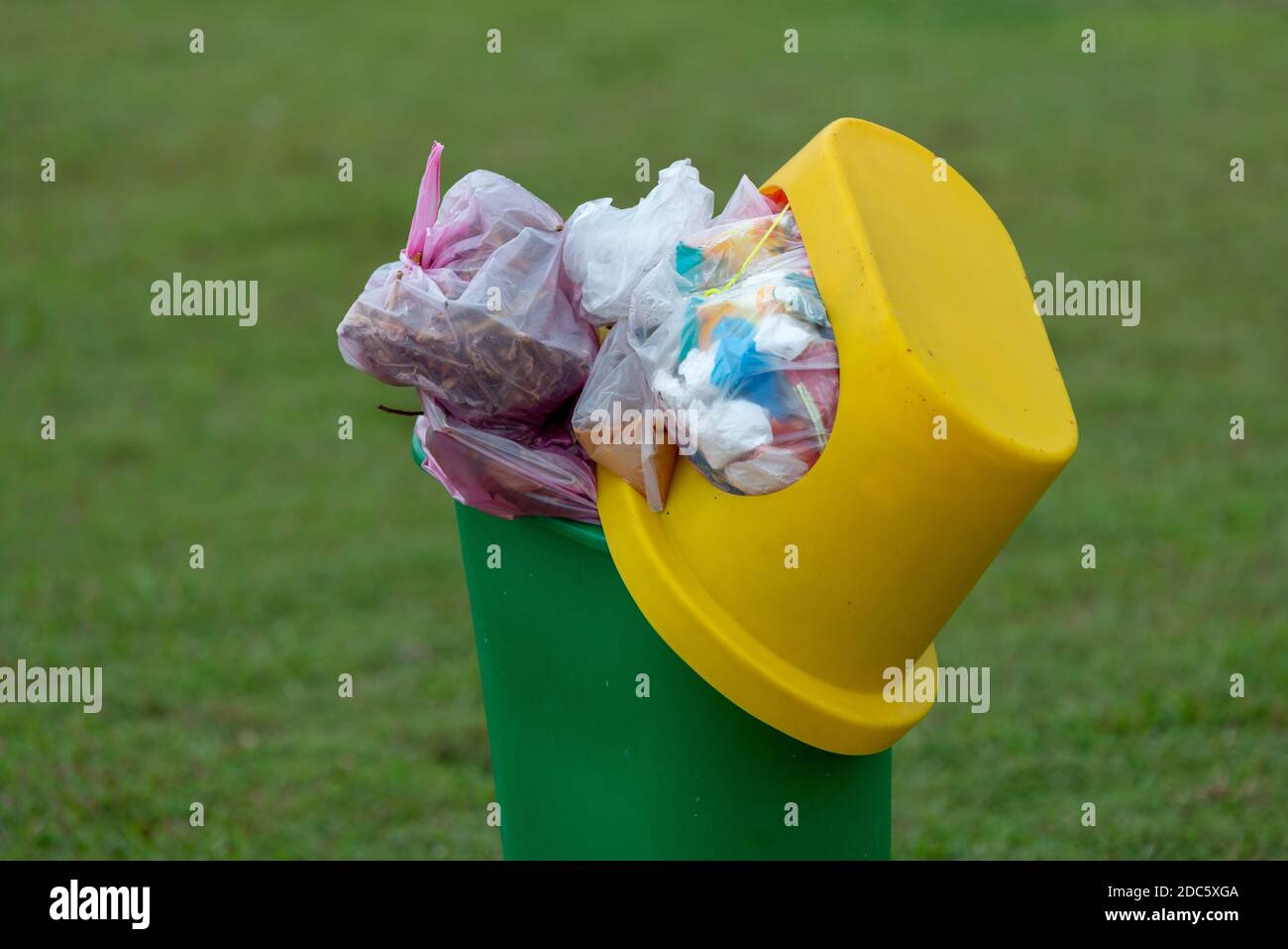 A closeup focus shot of a full dustbin at a park Stock Photo - Alamy