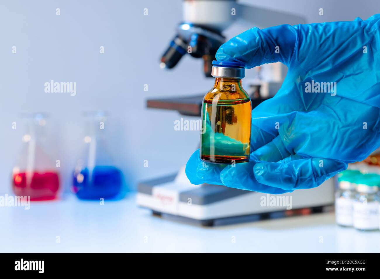 Doctor hands holding glass vial with medication Stock Photo - Alamy
