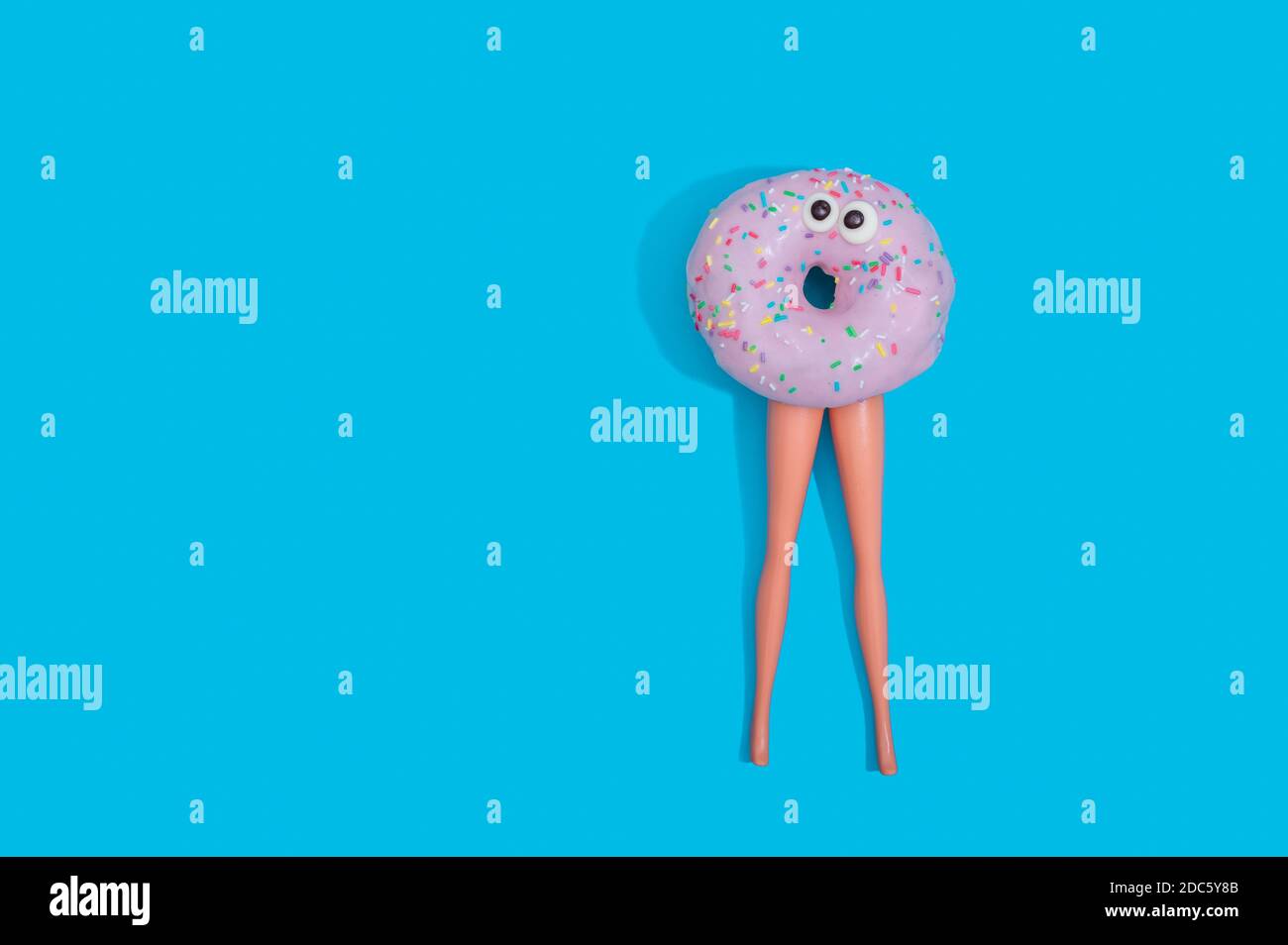 A funny pink donut with human legs on a blue background Stock Photo - Alamy