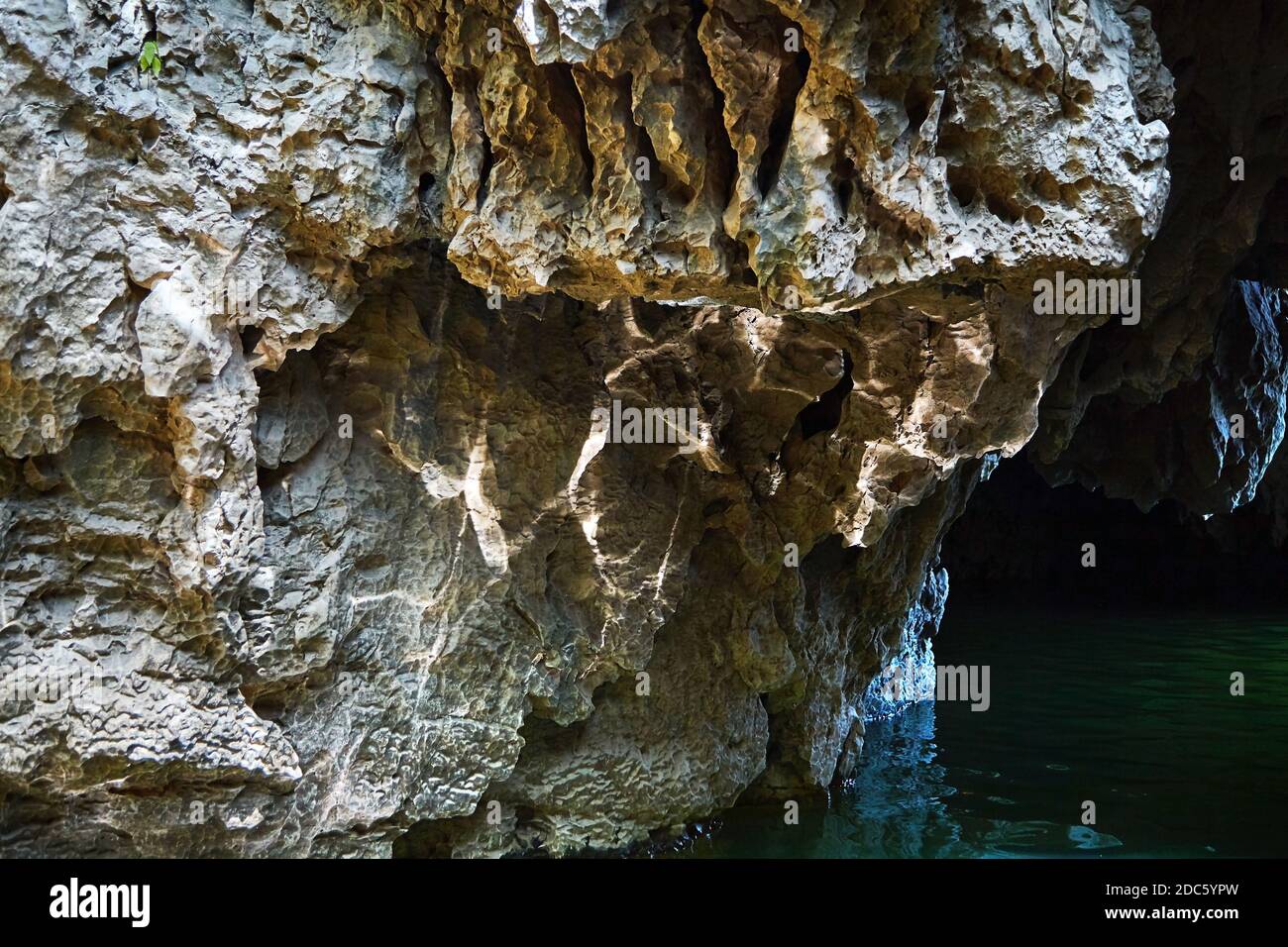 Cave in rock filled with river water. Glare on the stone surface of the ...