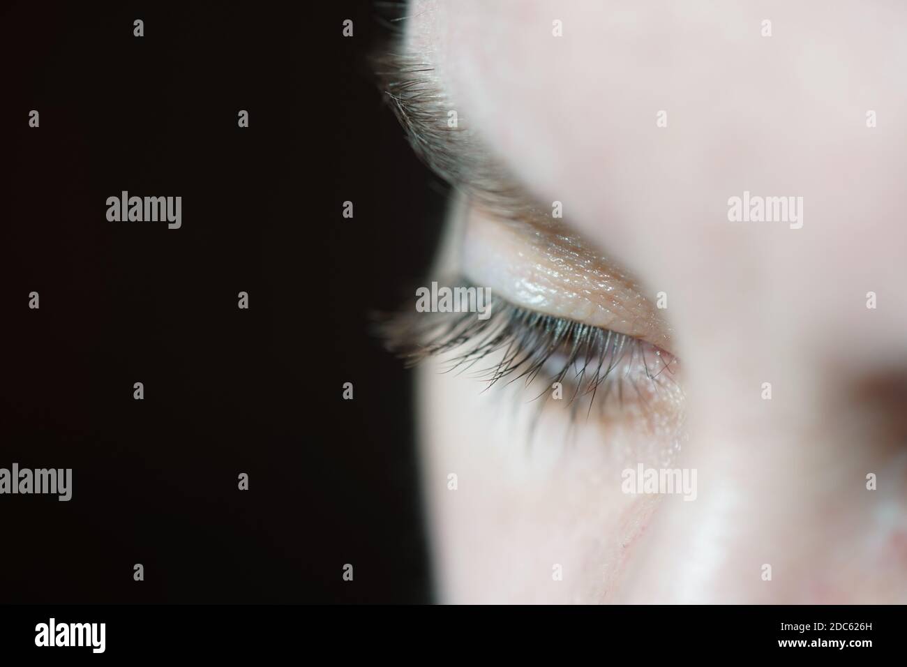 part of human face with look down in black background Stock Photo - Alamy