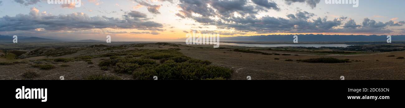 Panorama and sun on Issyk Kul Lake at sunset near Karakol with ...