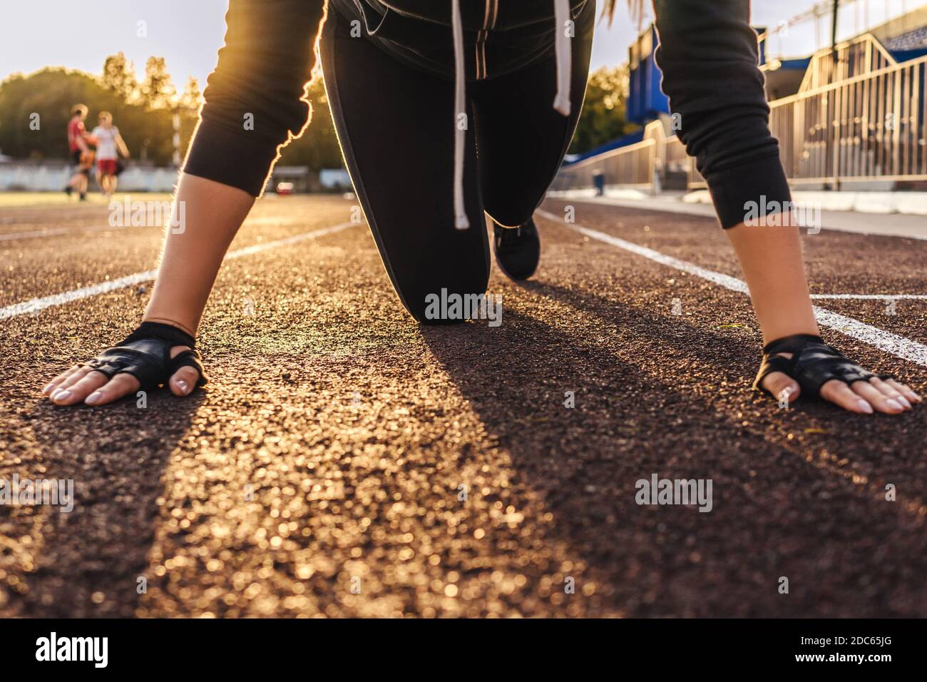 Young athletic woman resting after plank exercise on running track ...