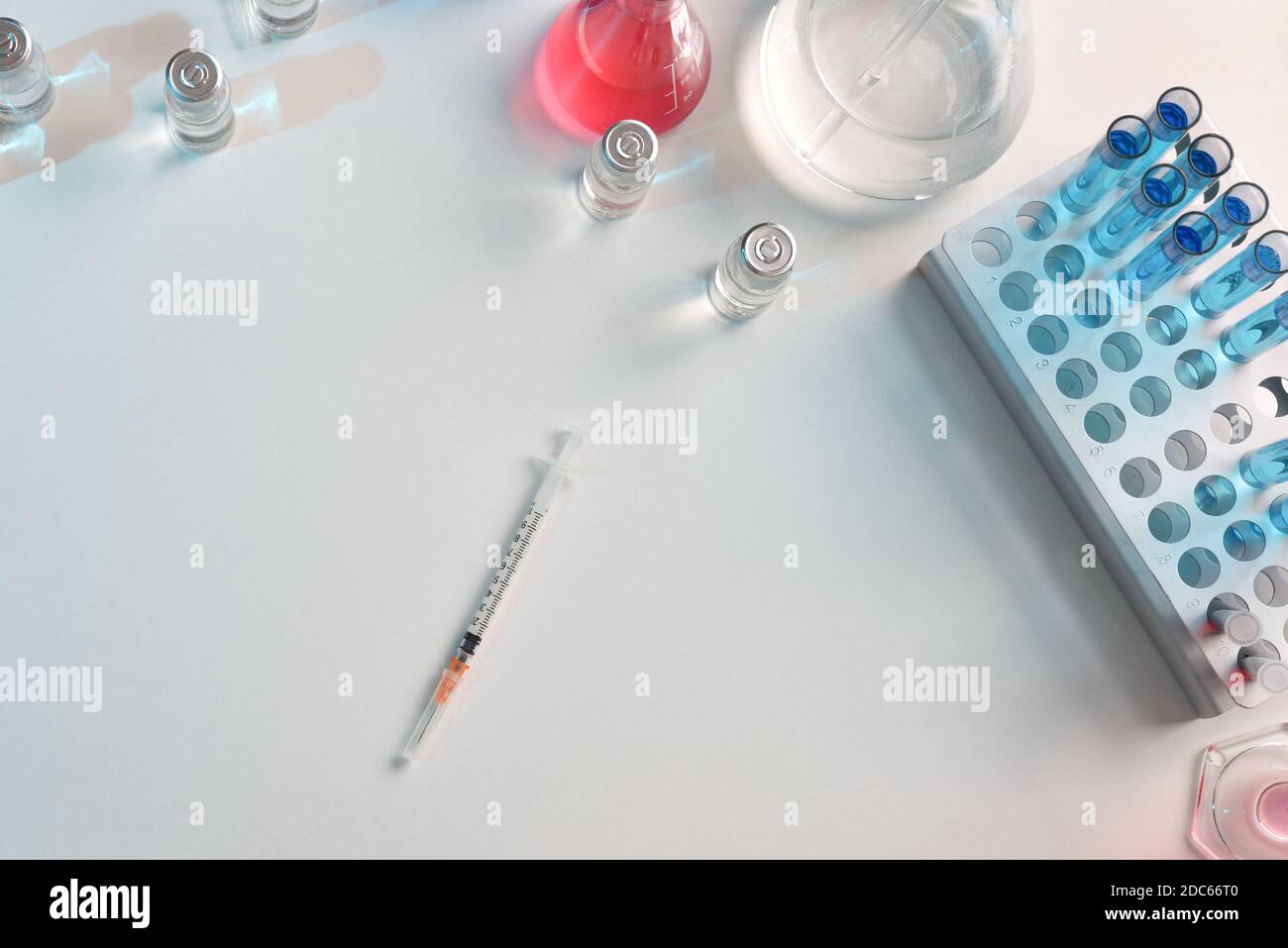 Disposable syringe on a table in a pharmaceutical laboratory with vials ...