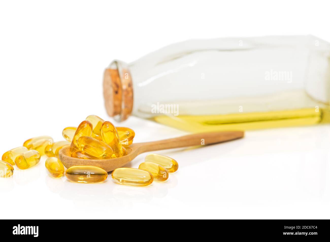 Bottle of fish oil and omega 3 in a wooden spoon, isolated on a white ...