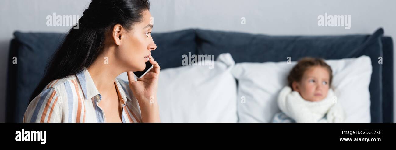 worried mother looking at diseased daughter while calling by mobile ...