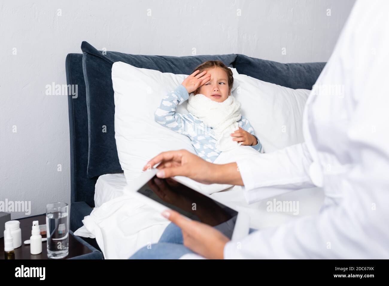 pediatrician holding digital tablet with blank screen near sick child ...