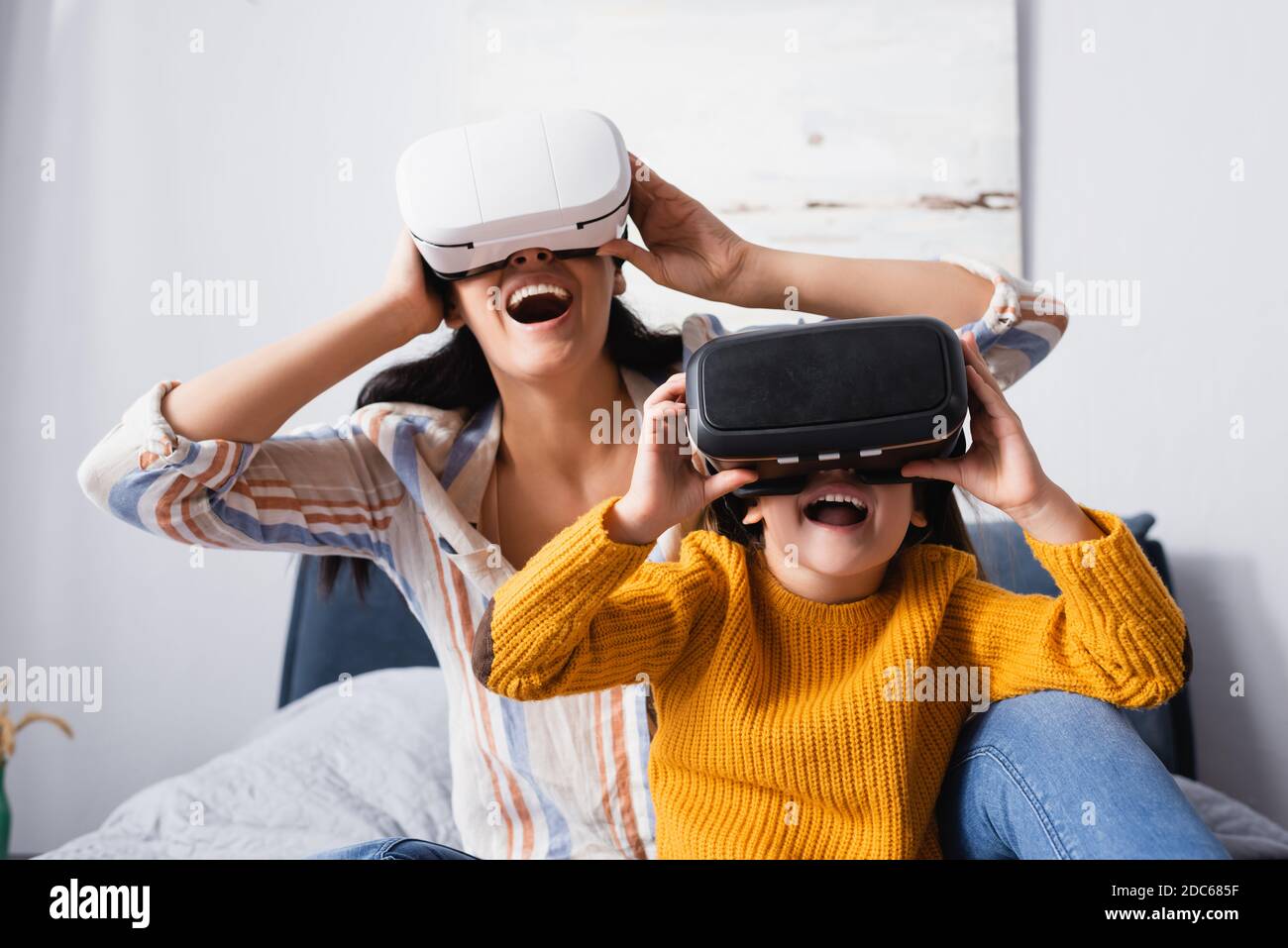 excited child with mother using vr headsets in bedroom Stock Photo - Alamy