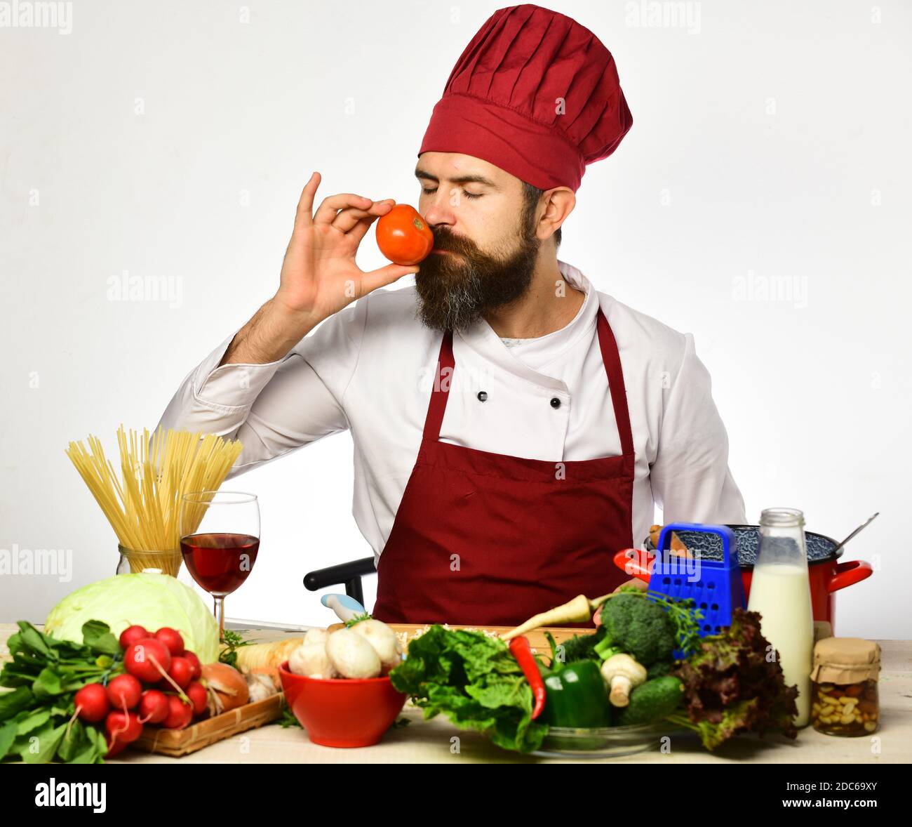 Professional cookery concept. Cook with dreamy face in burgundy uniform ...