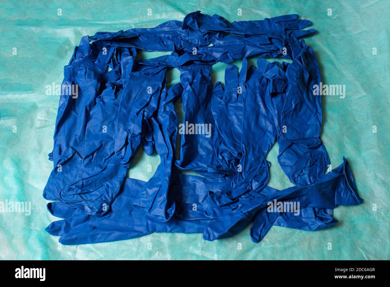Blue gloves piled on green sanitary cloth. Hand and arm protection ...