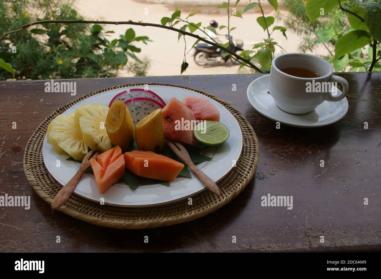 Afternoon tea sipped with delicious fruit platter on a cafe balcony ...