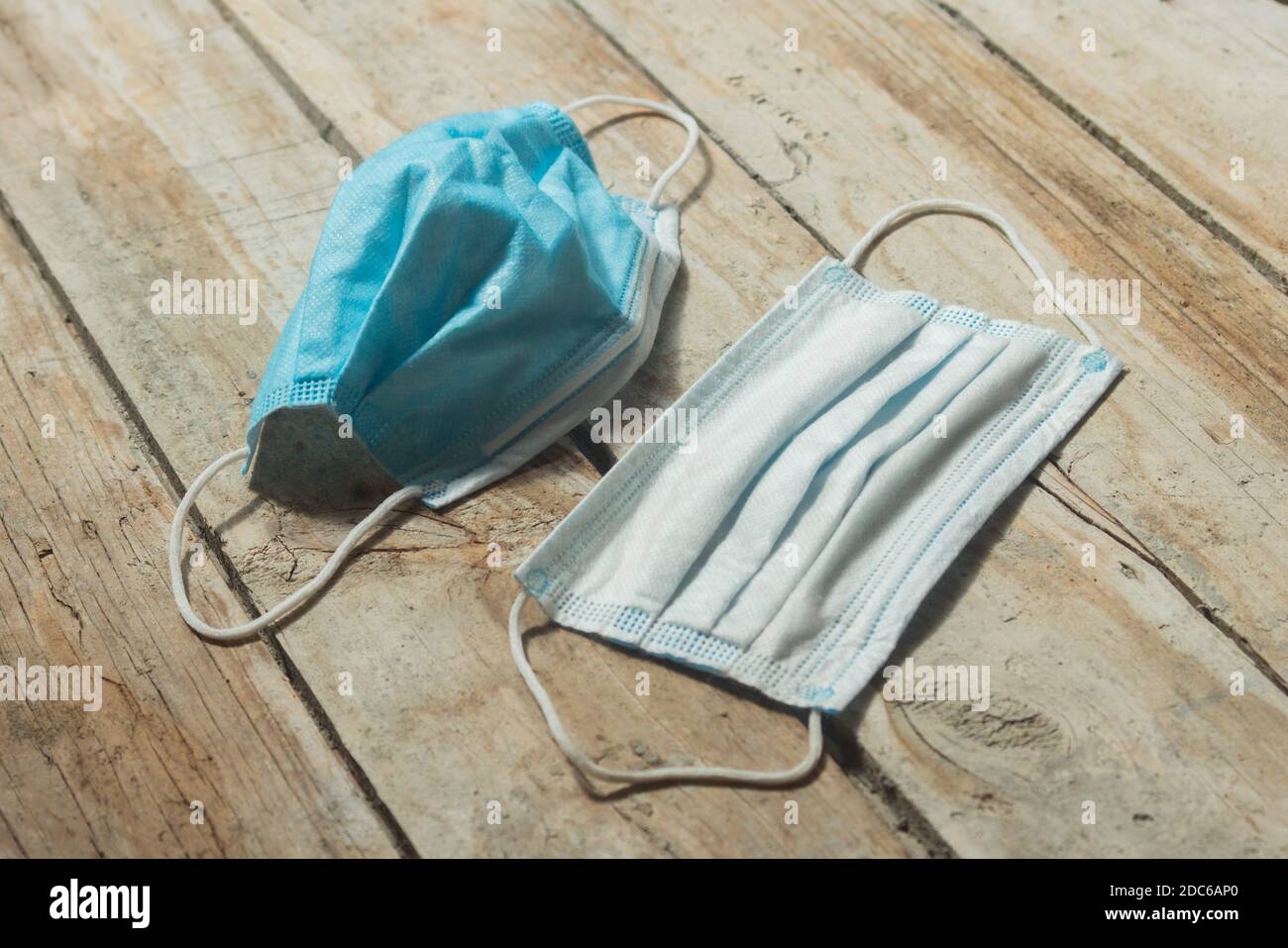 Two surgical masks, one face up and one upside down, rest on an old ...