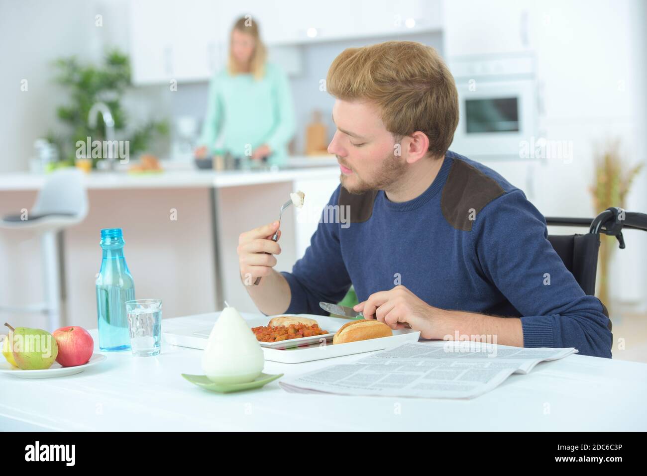 disabled man in wheelchair eating at home Stock Photo - Alamy