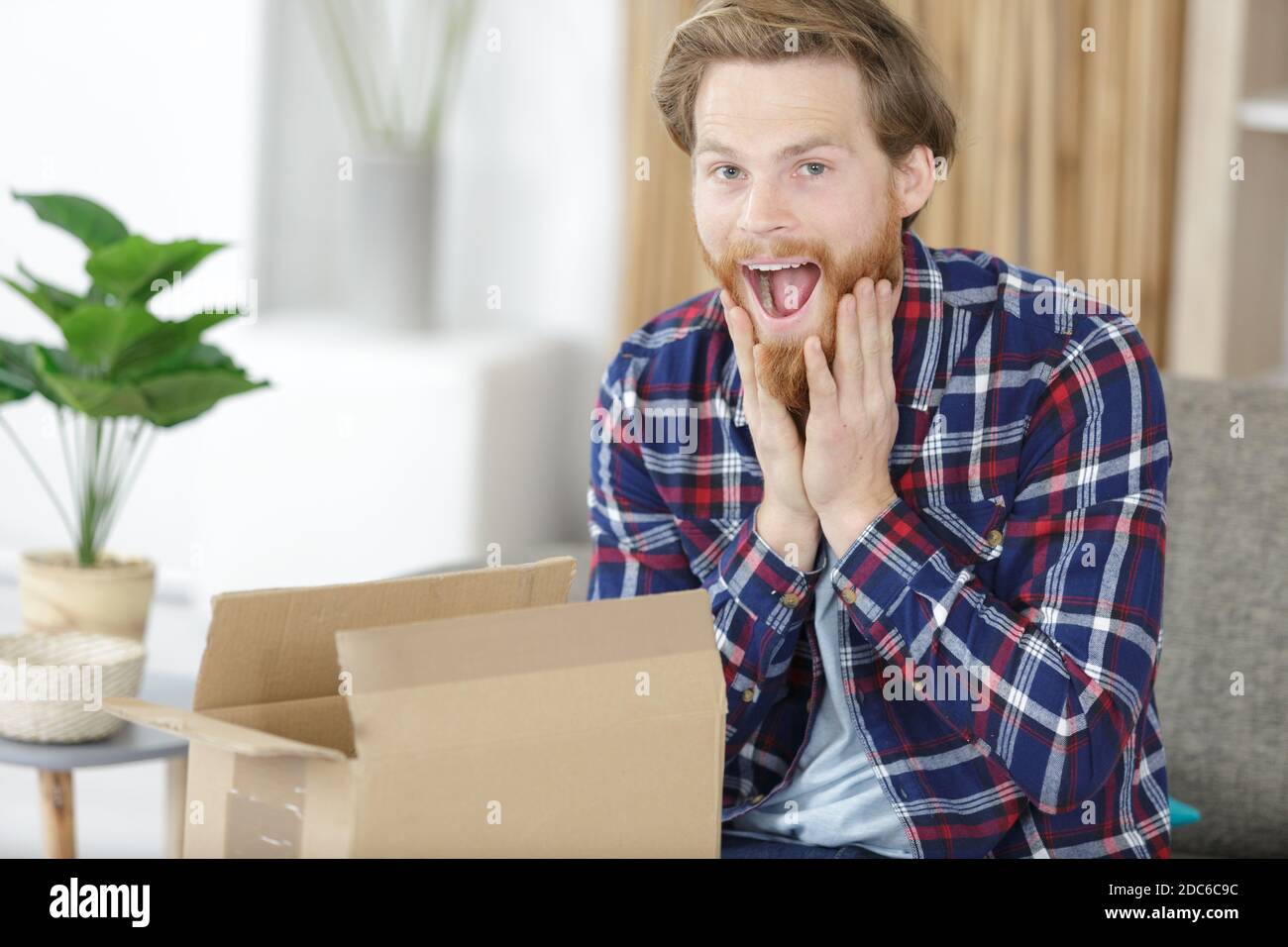 surprised man opening carton box Stock Photo - Alamy