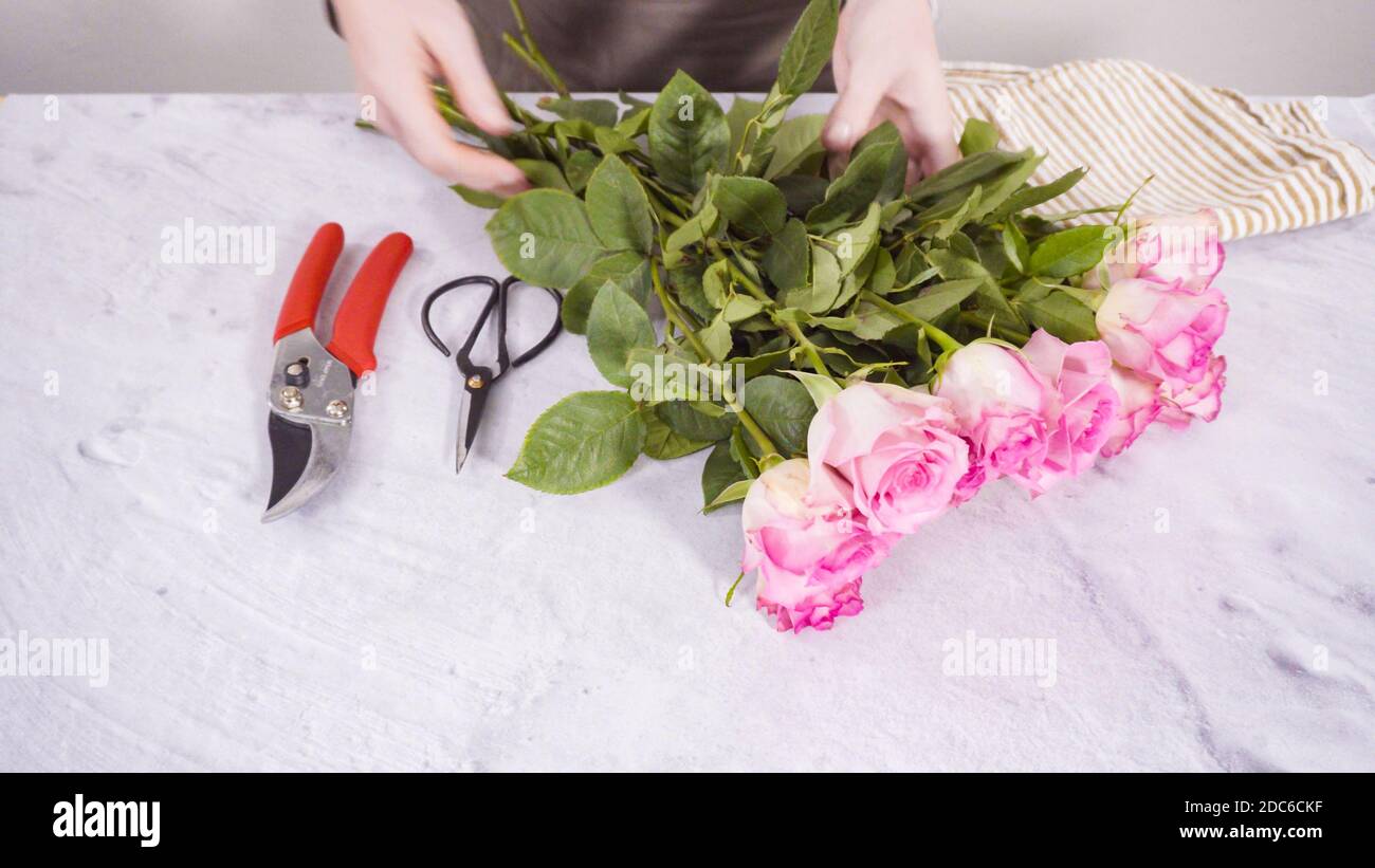 Step by step. Florist arranging a bouquet from pink roses Stock Photo ...
