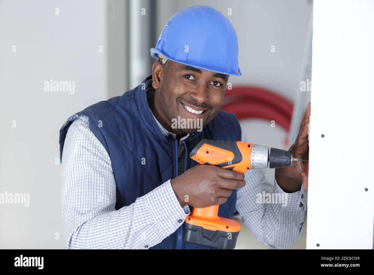 builder using electric drill on wall Stock Photo - Alamy