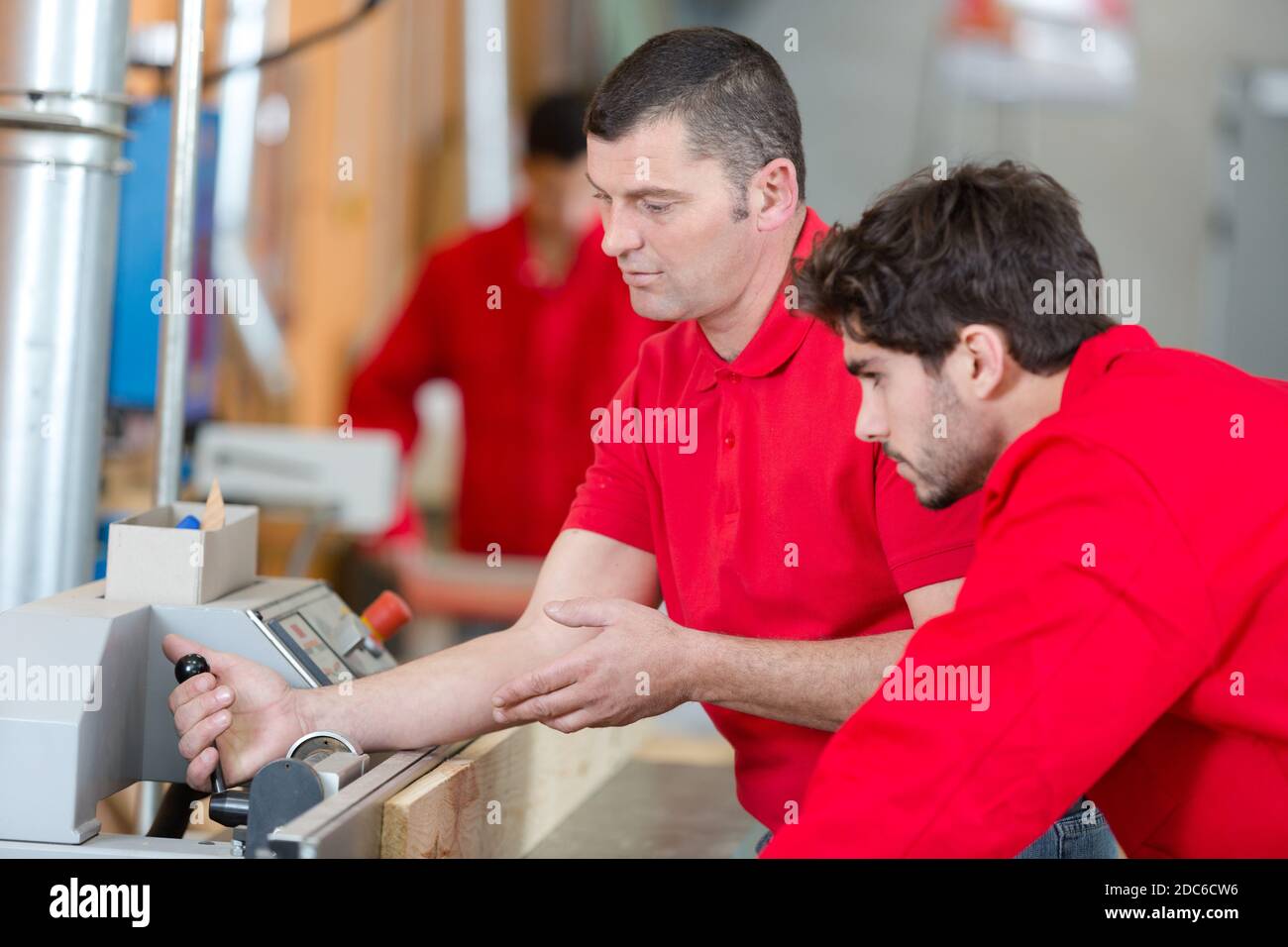 two workers operating on machine Stock Photo - Alamy