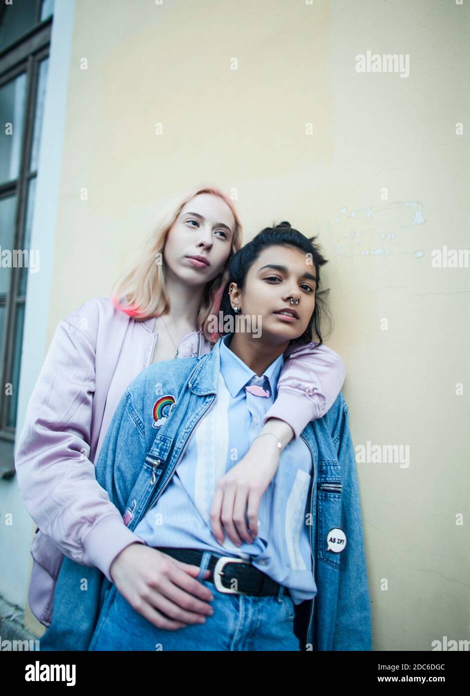 Two teenage girls infront of university building smiling, having fun ...
