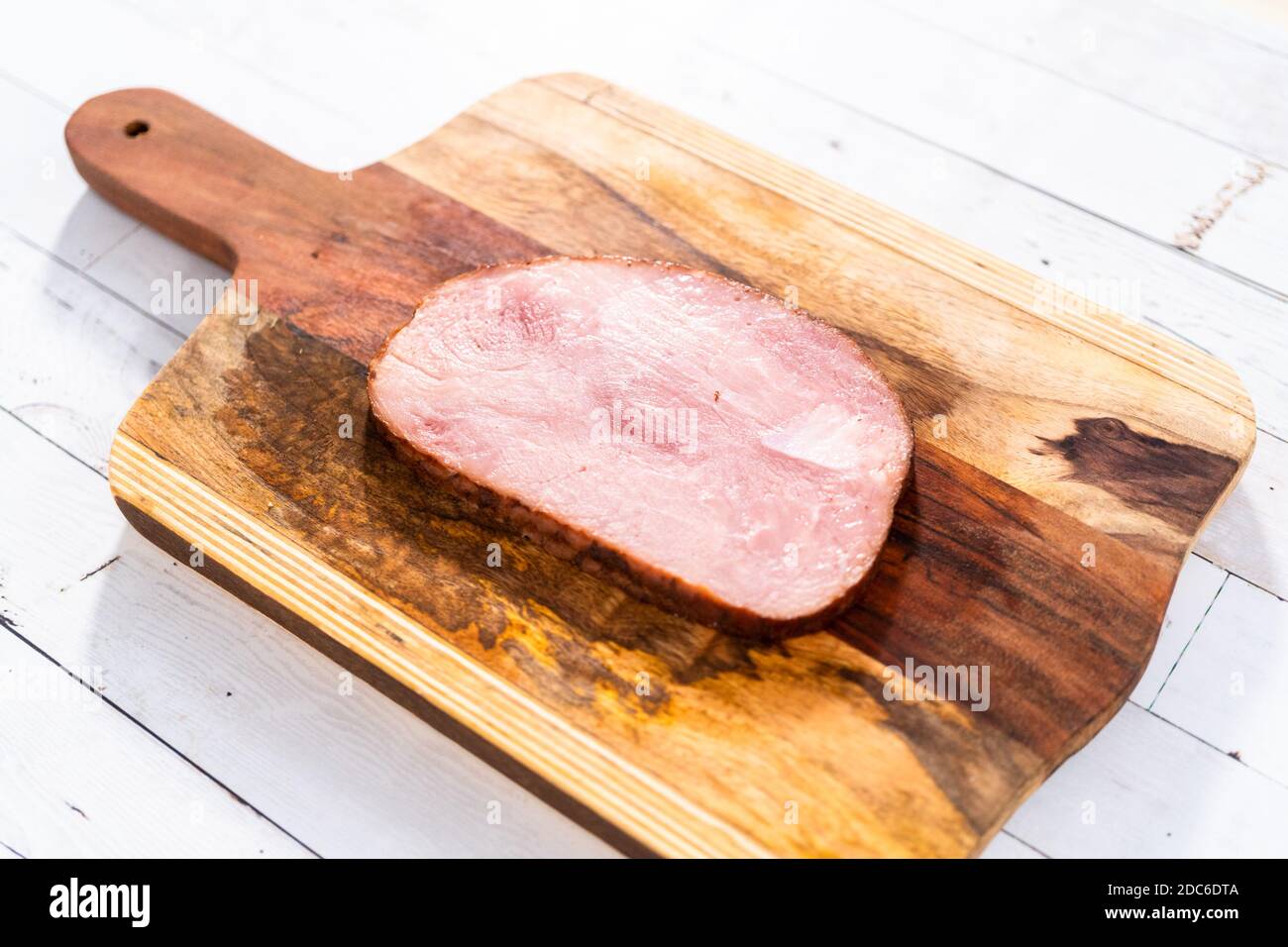 Slice of organic honey ham on a wood cutting board Stock Photo - Alamy