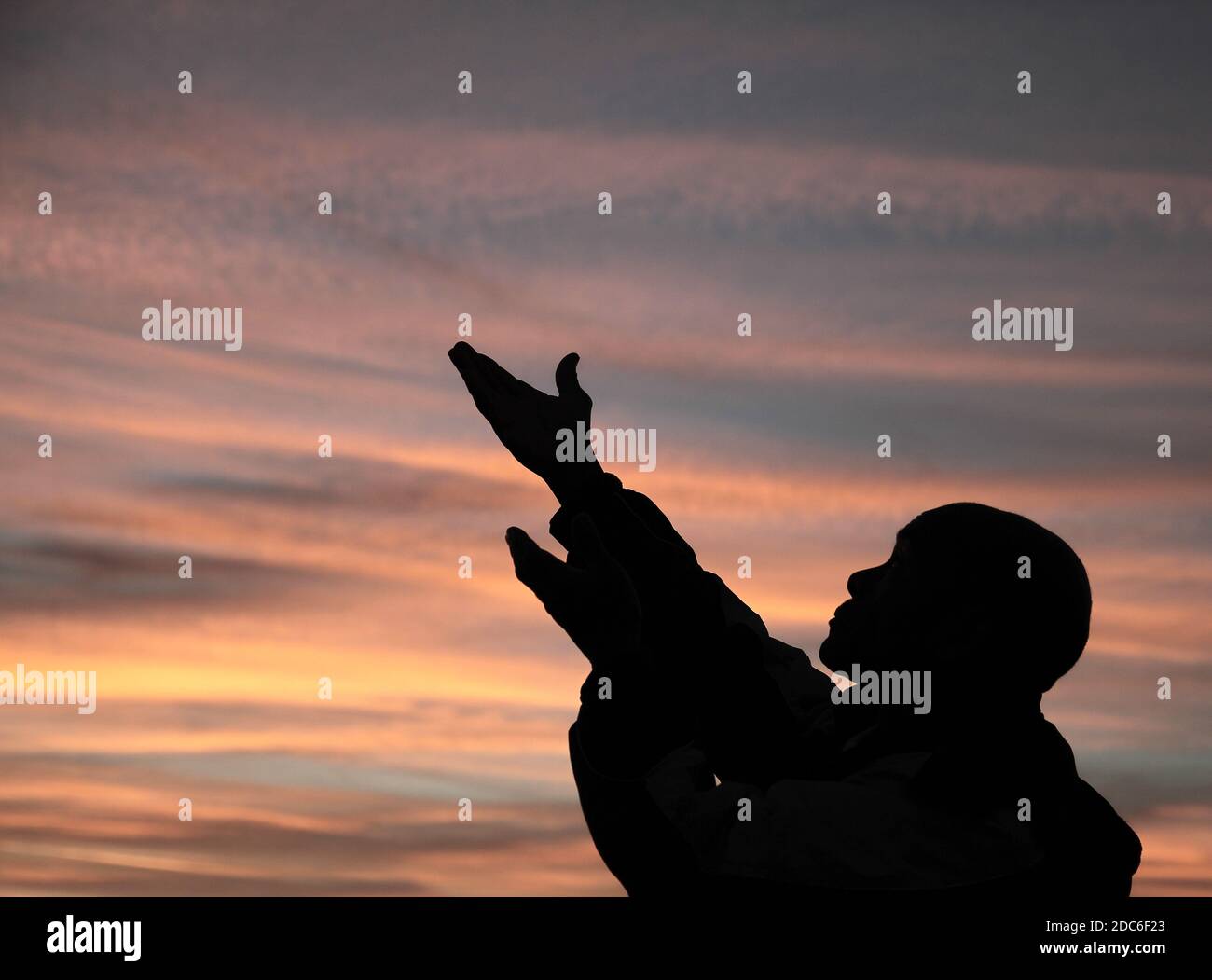 praying to god with arms outstretched to the sky sunset stock photo ...