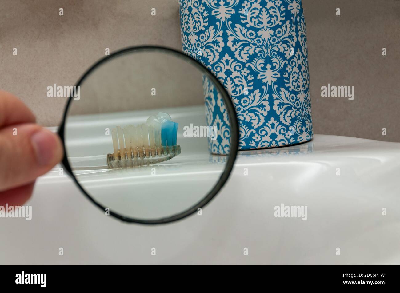 An old and dirty toothbrush with germs seen with a magnifying glass ...