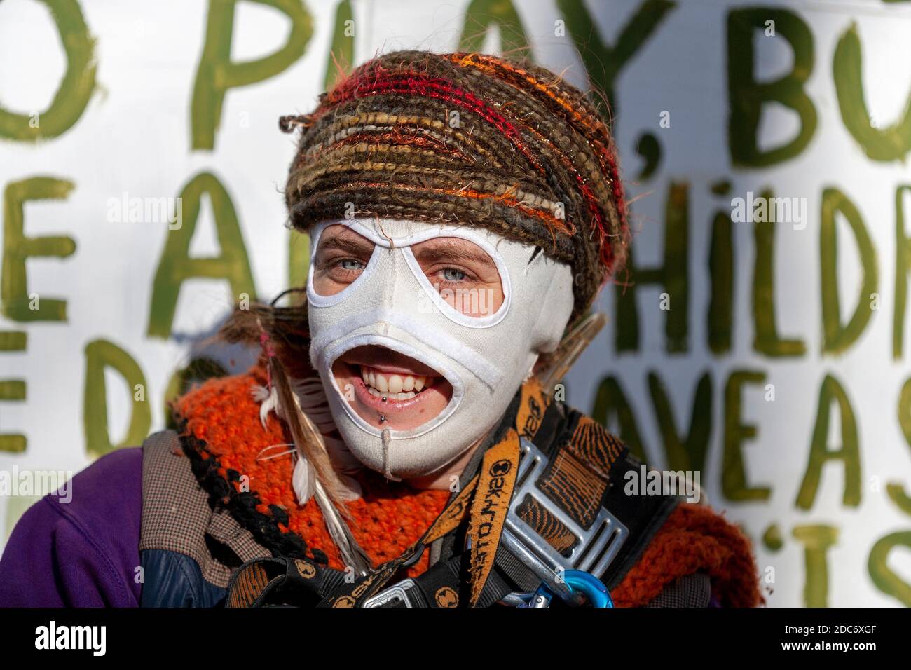 An Extinction Rebellion activist named Peacock smiles behind a ...