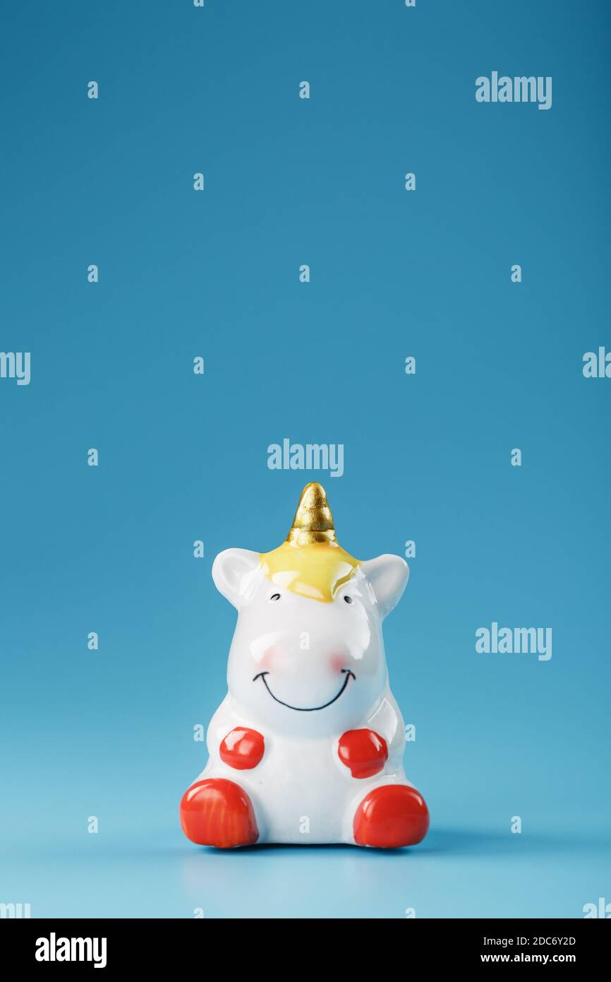 Unicorn figurine on a blue background with free space. Symbol of good ...