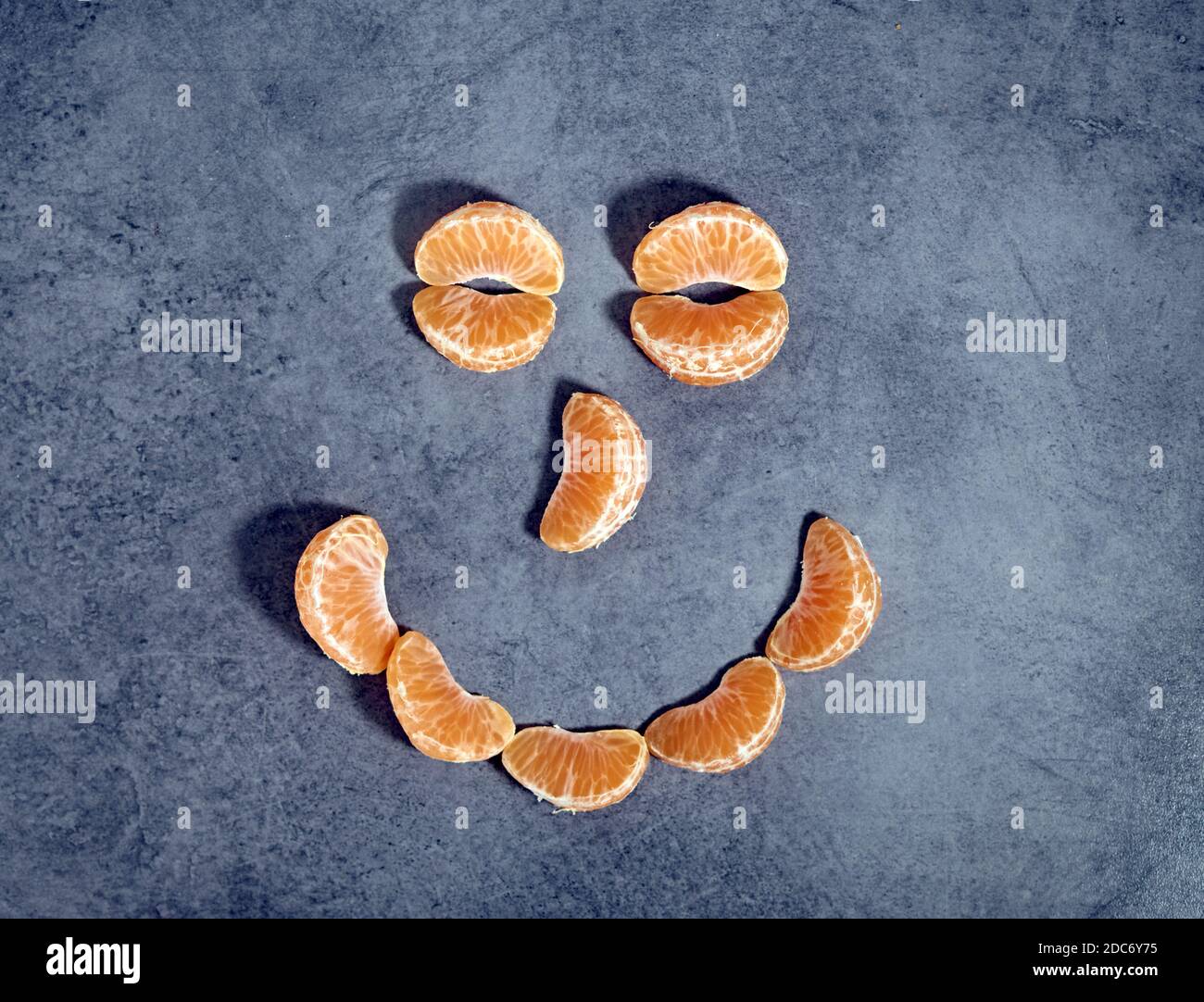 A high angle shot of tangerine pieces shaped like a smiley face Stock ...