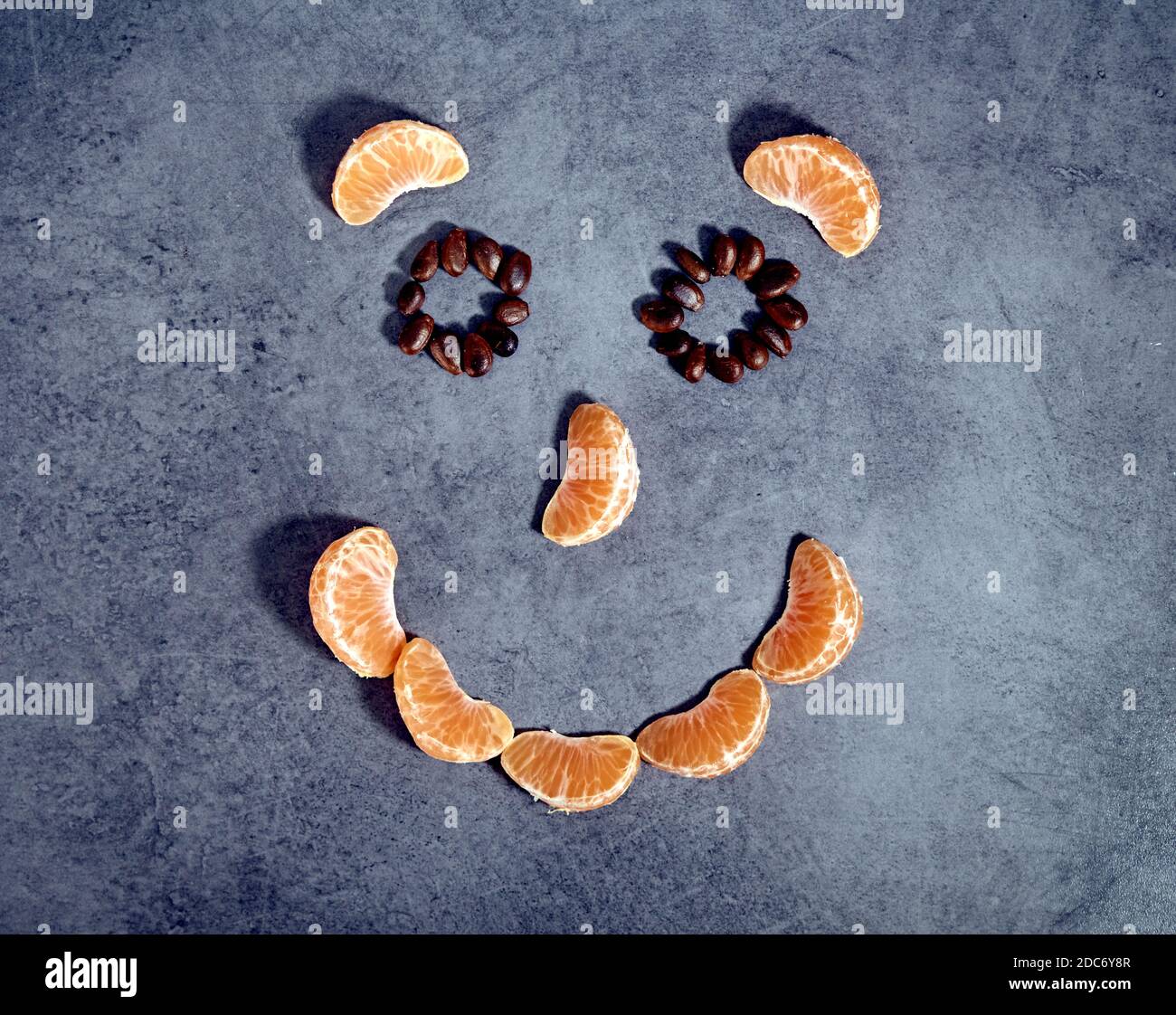 A high angle shot of tangerine pieces and seeds shaped like a smiley ...
