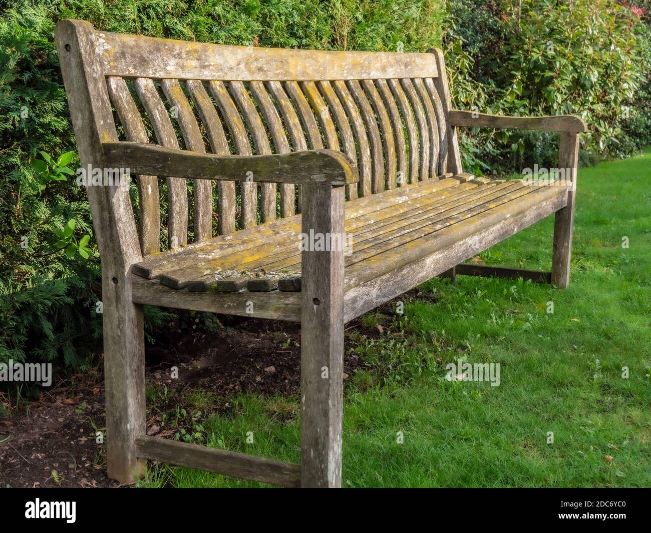 A twenty years old, unoccupied, wooden bench / seat, facing the ...
