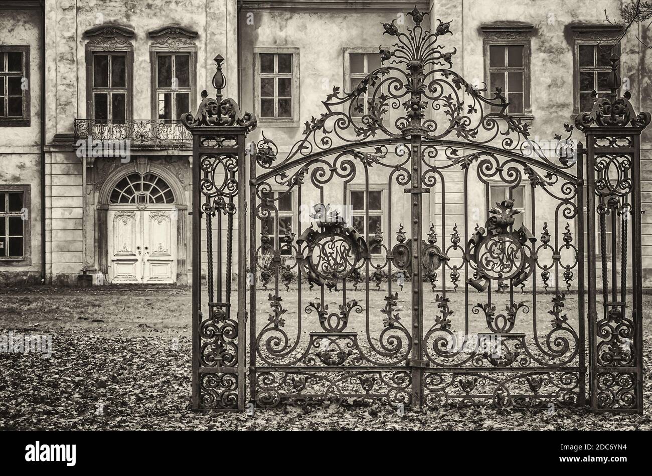 An old iron gate is placed in front of a dilapidated baroque manor house, Ivenack Manor ...