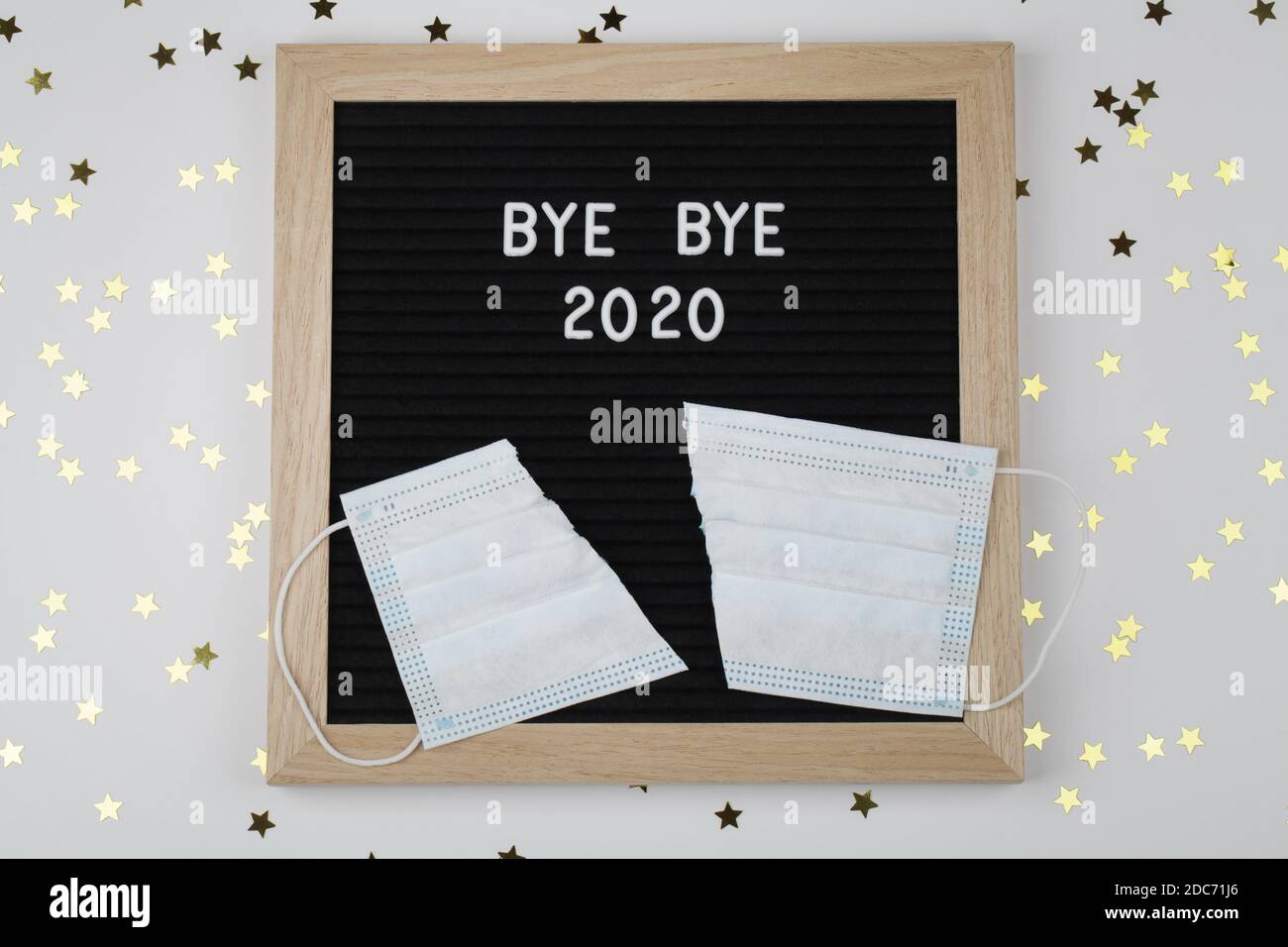 black letter board with text BYE BYE 2020 with cut mask on white ...