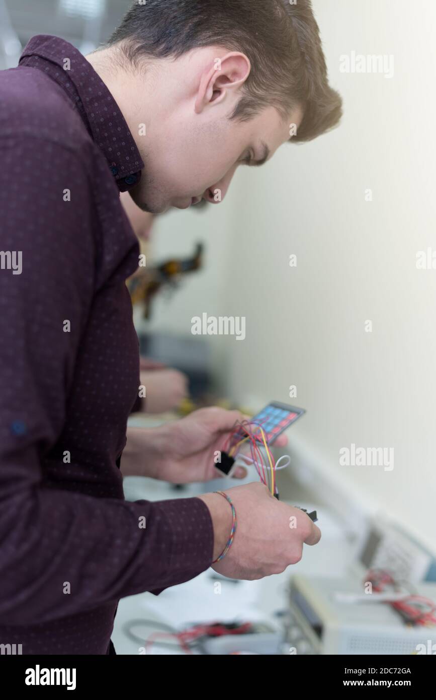 Scientists engineers designing small human robot, setting artificial ...