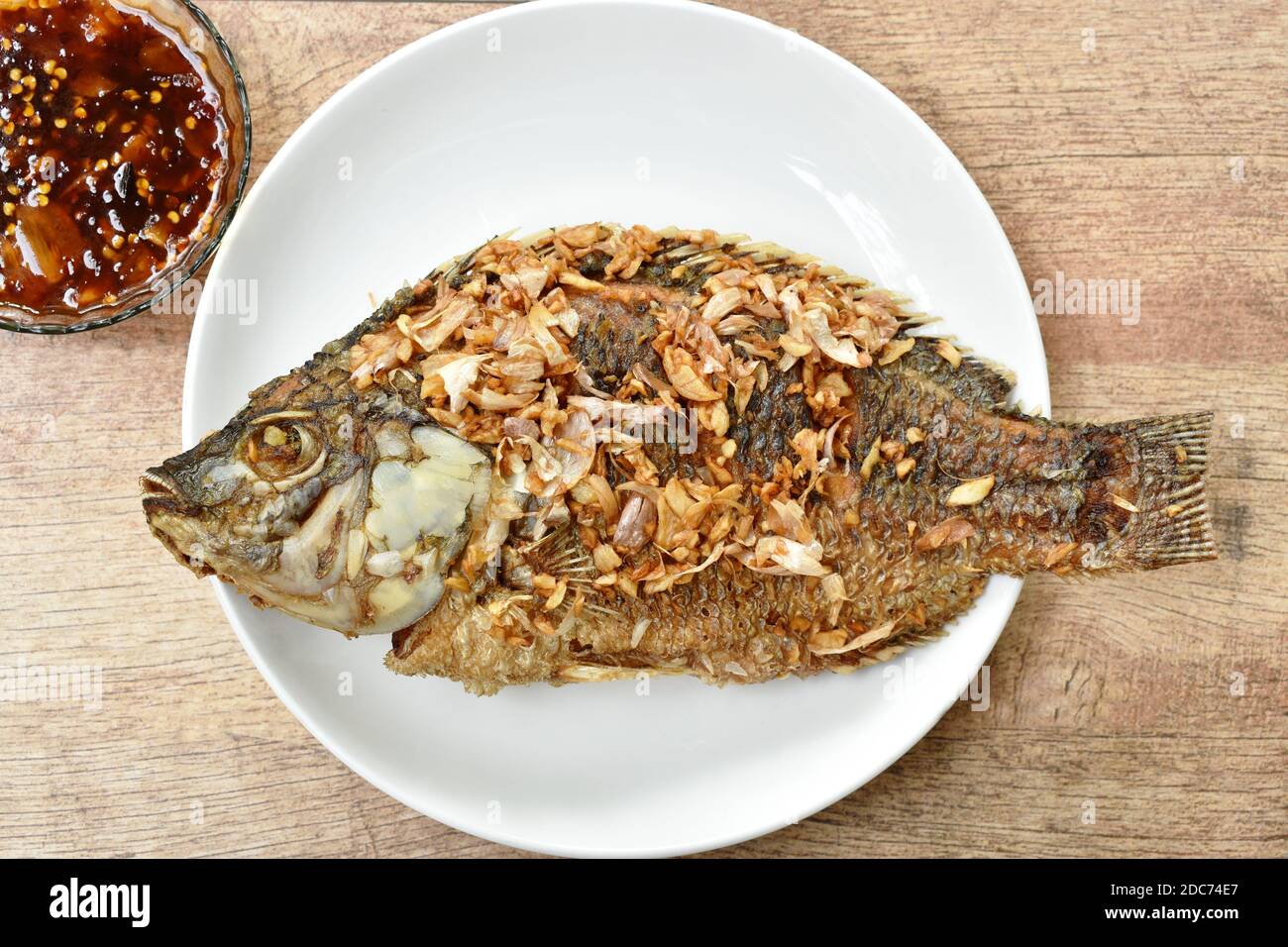 batter fried mango fish topping chop garlic on plate dipping sweet ...