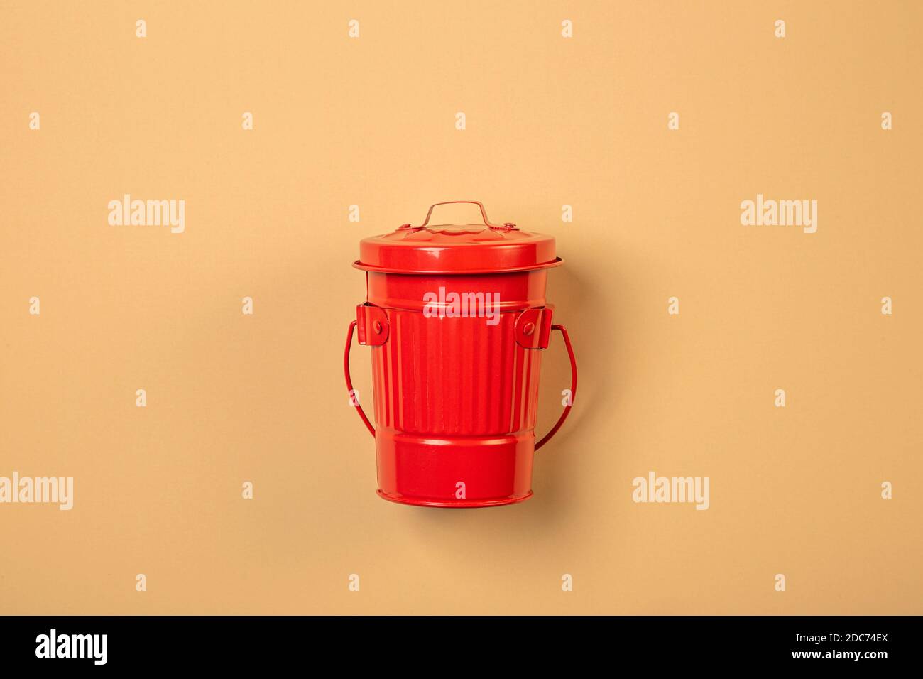 red iron garbage container on a cream background Stock Photo - Alamy