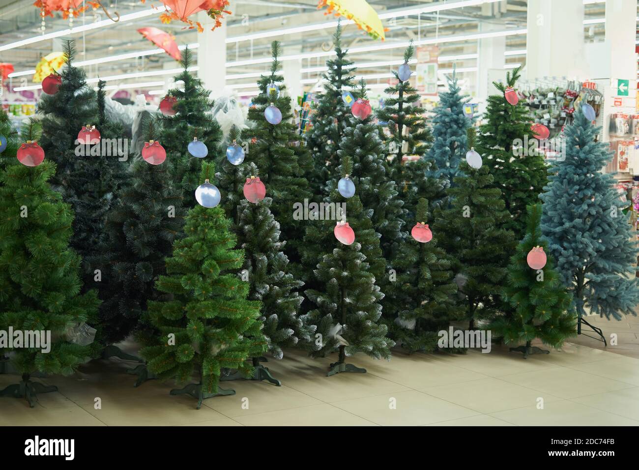 Selling various artificial Christmas trees in the store Stock Photo - Alamy