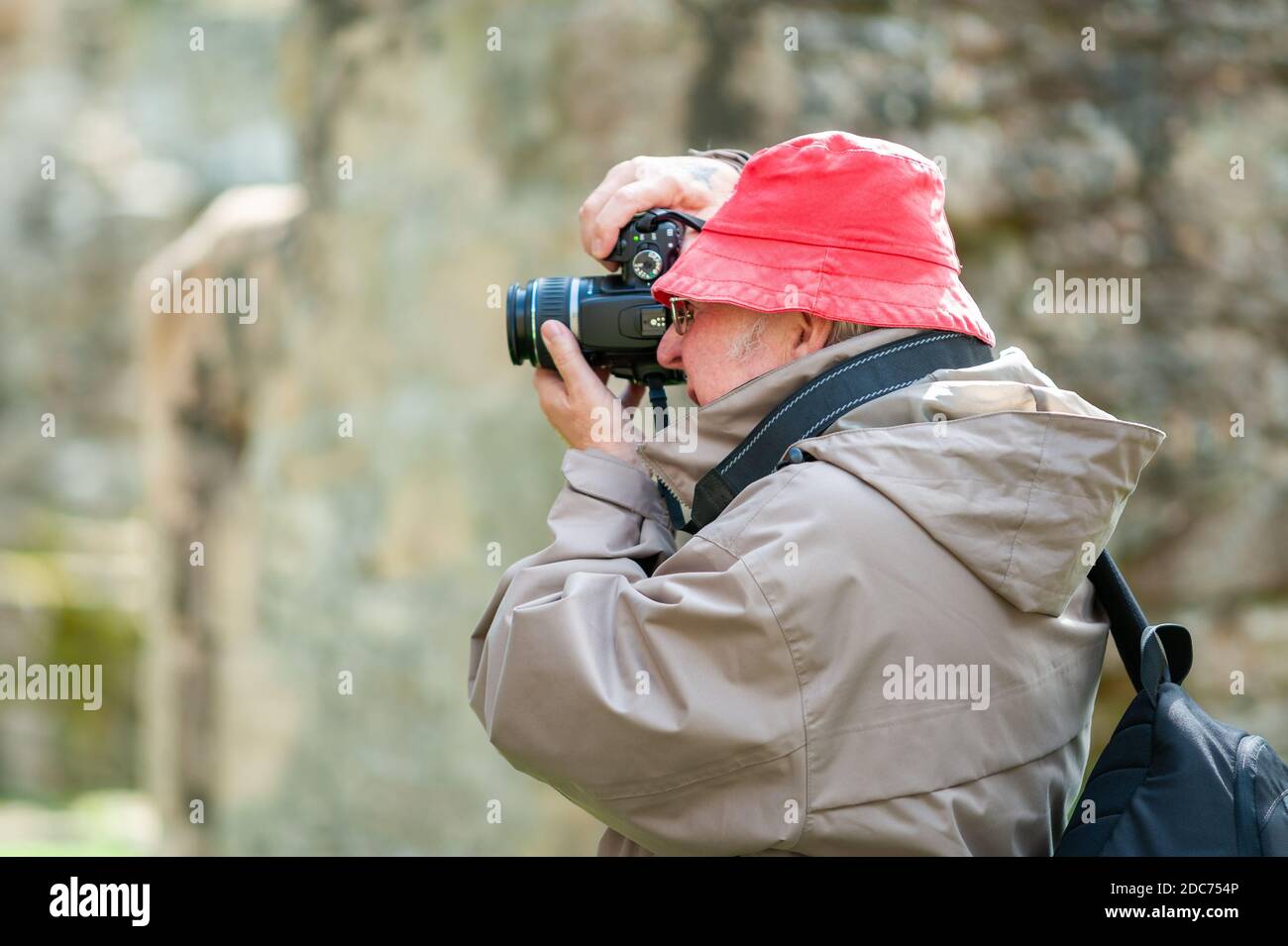 An elderly man uses a camera in ancient ruins Stock Photo - Alamy