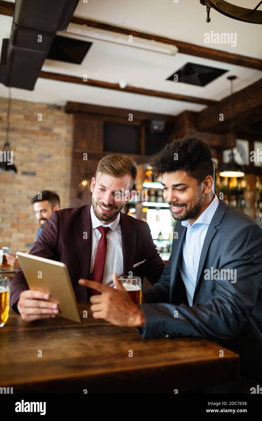 Confident business men talking and working together in a restaurant ...