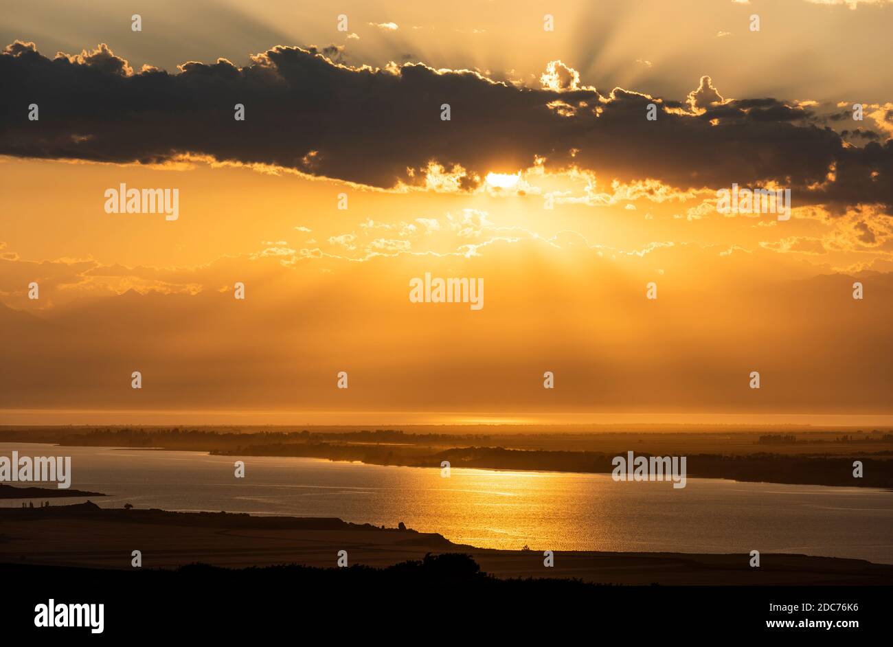 Sun beams on Issyk Kul Lake at sunset near Karakol in Kyrgyzstan Stock ...