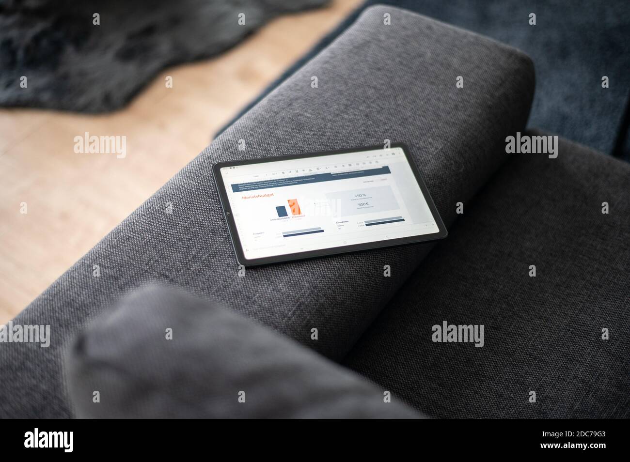 a tablet lies with an open table calculation on a sofa backrest with ...