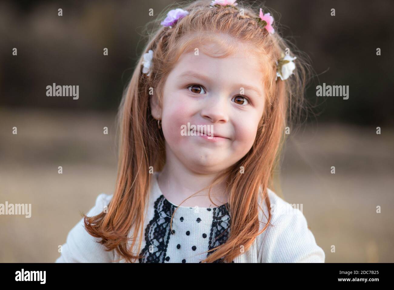 Portrait of an adorable, ginger little girl smiling and making funny ...