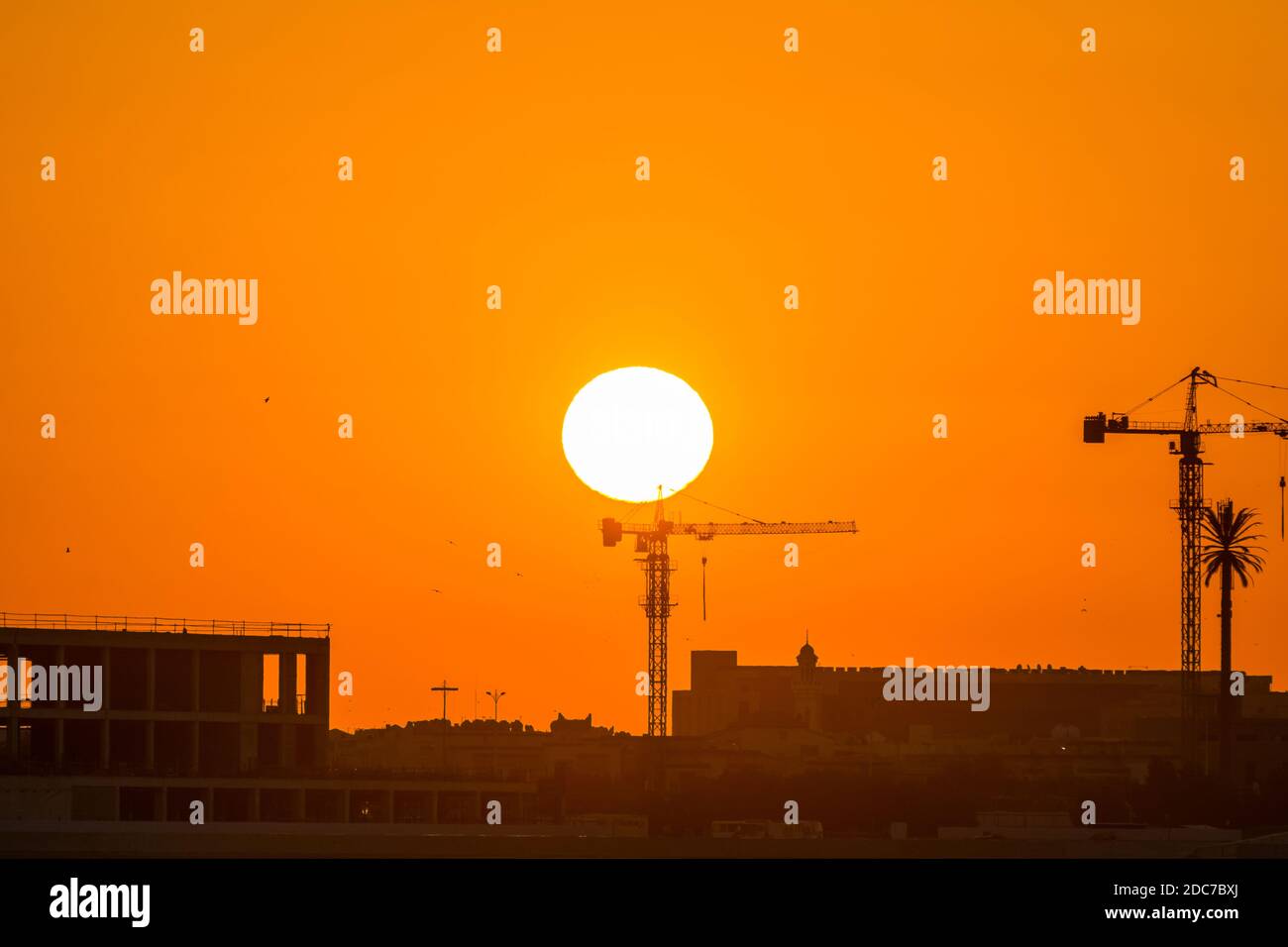 Landscape of sun rising over the construction site with crane in the ...