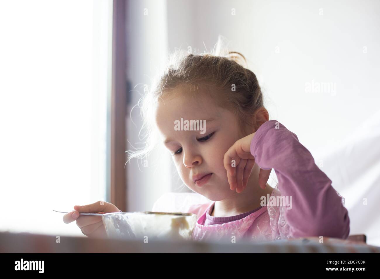Little blonde girl having lunch Stock Photo - Alamy