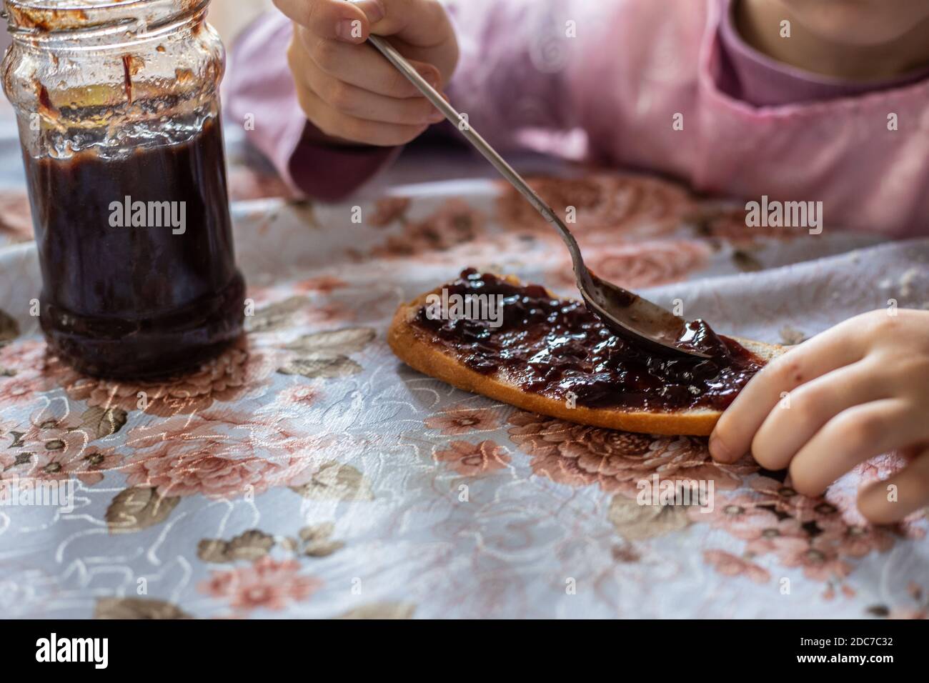 Close up of a child eating bread with jam Stock Photo - Alamy