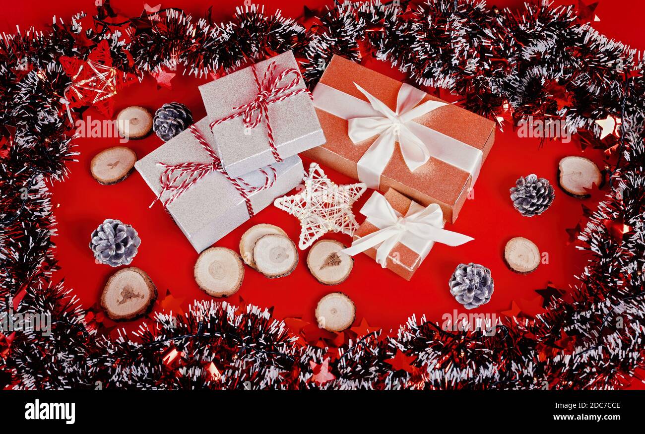 Christmas still life with shimmering gift boxes, wood, cones and ...
