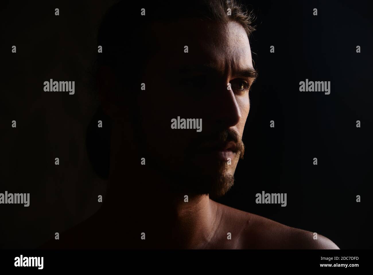Handsome young man with half of face in shadow Stock Photo - Alamy