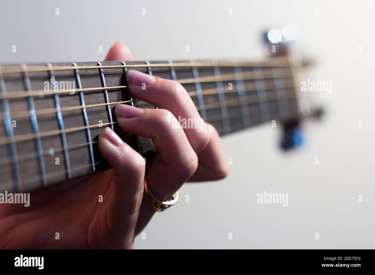 A female hand plucking a western guitar Stock Photo - Alamy